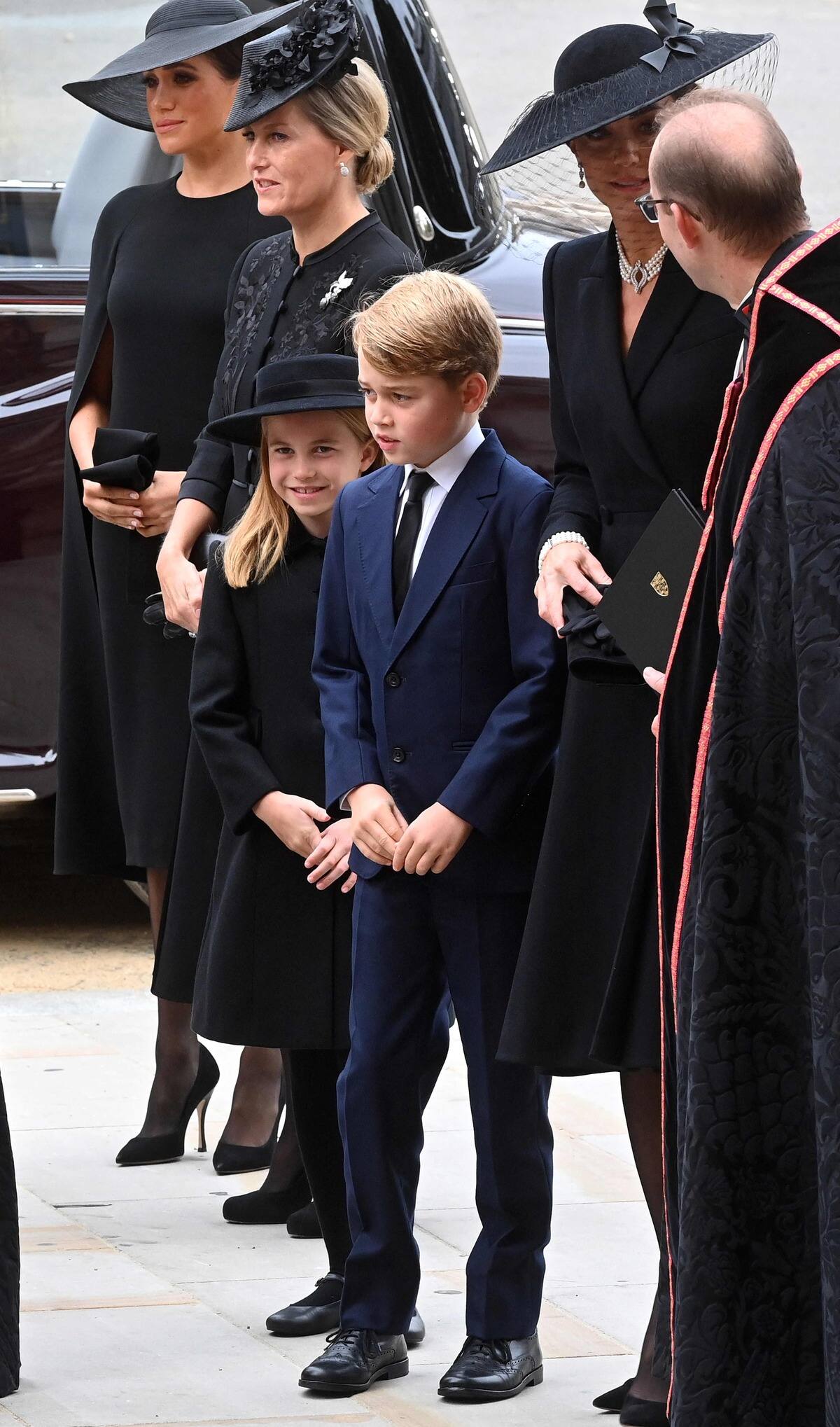 George et Charlotte, petits princes solennels derrière le cercueil de ...